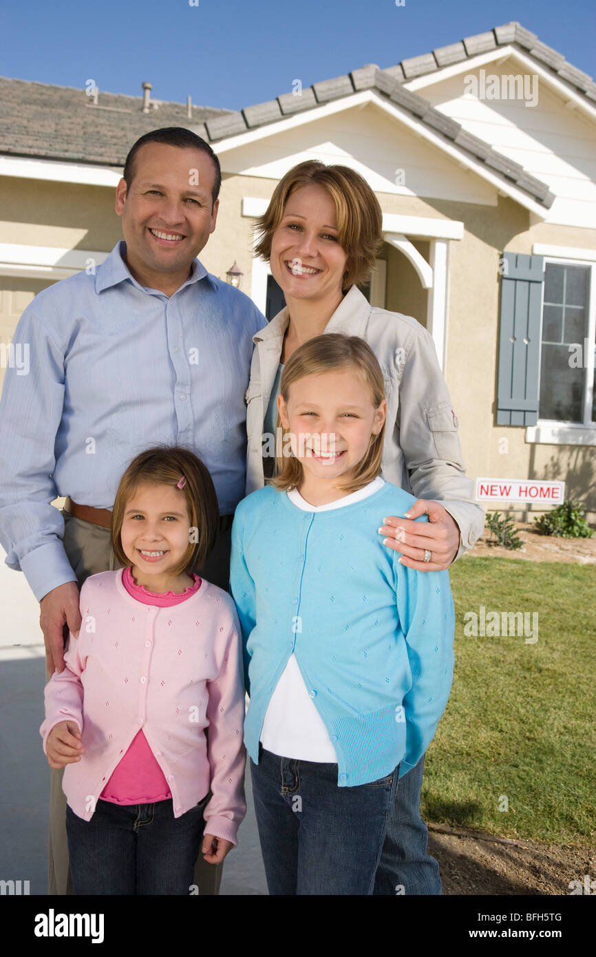 Portrait of family with two children (6-9) in front of new house Stock ...