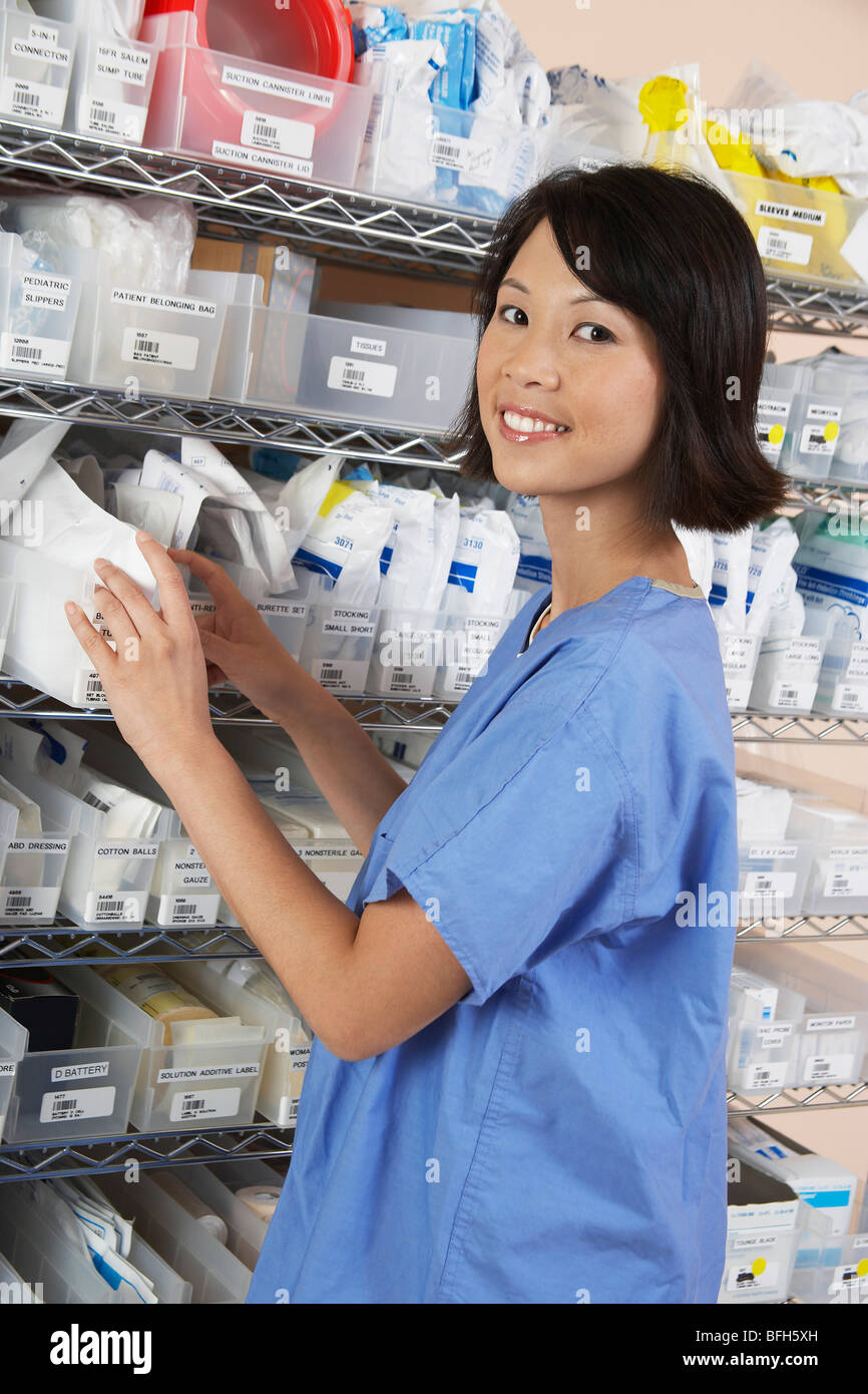Female nurse standing at shelf with medicines, portrait Stock Photo - Alamy