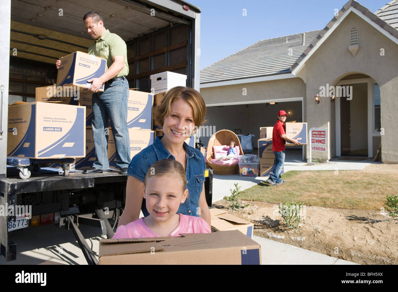 Portrait of family with daughter (7-9) unloading truck Stock Photo - Alamy