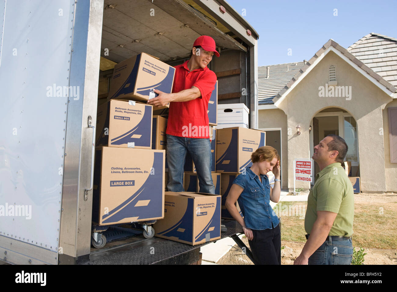 Man and couple unloading truck of cardboard boxes Stock Photo - Alamy