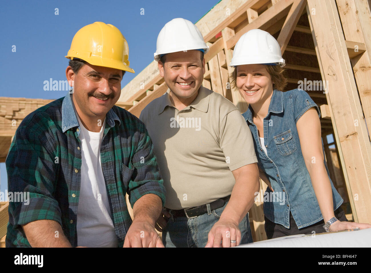 Two men and woman at construction site, portrait Stock Photo - Alamy