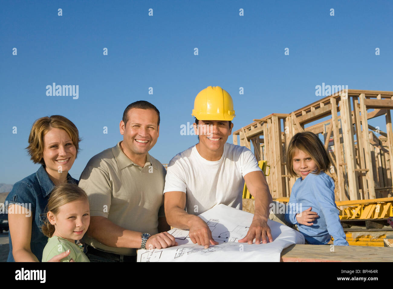 Portrait of family with two children (6-9) and construction side ...
