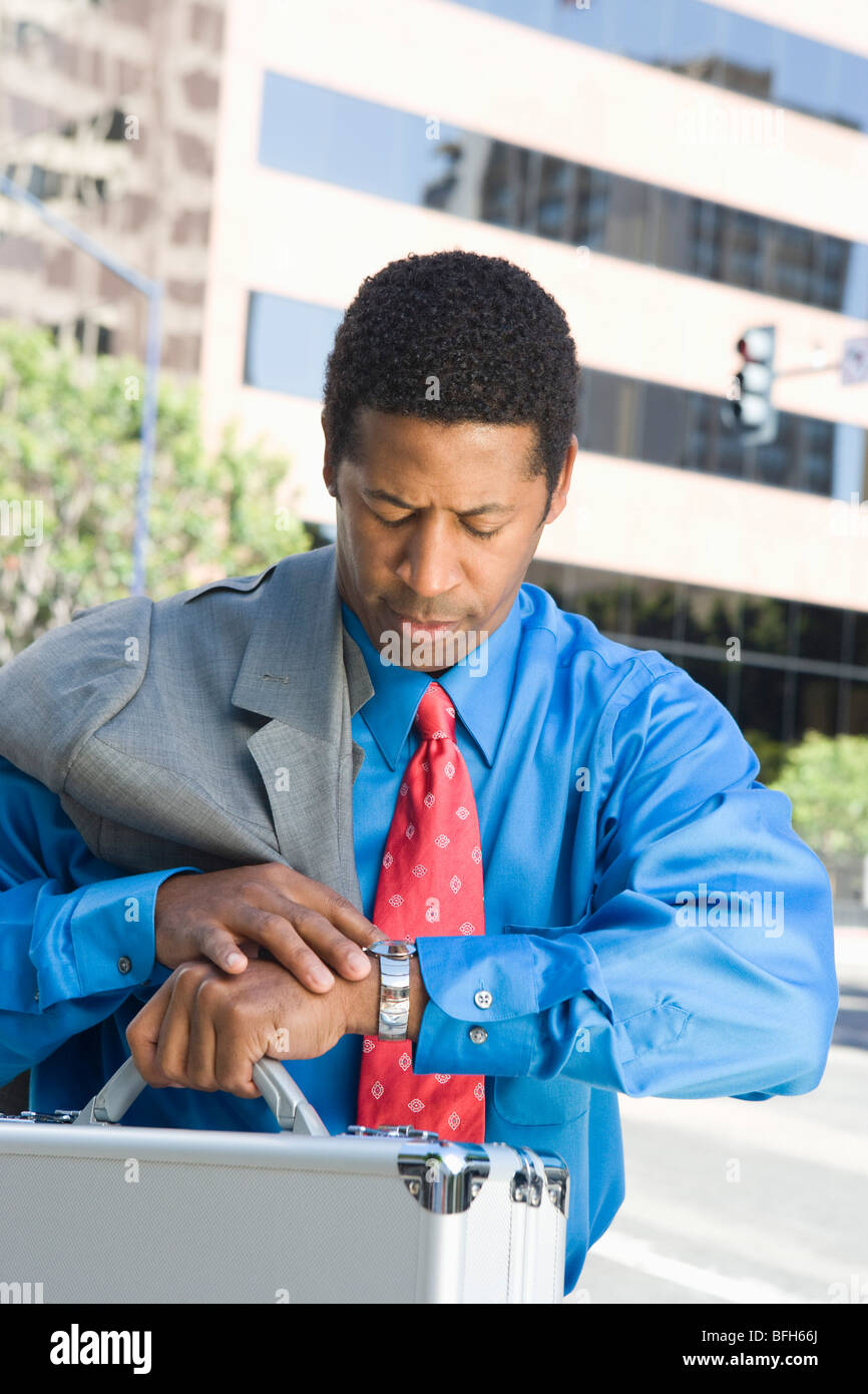 Mid-adult businessman checking time Stock Photo - Alamy