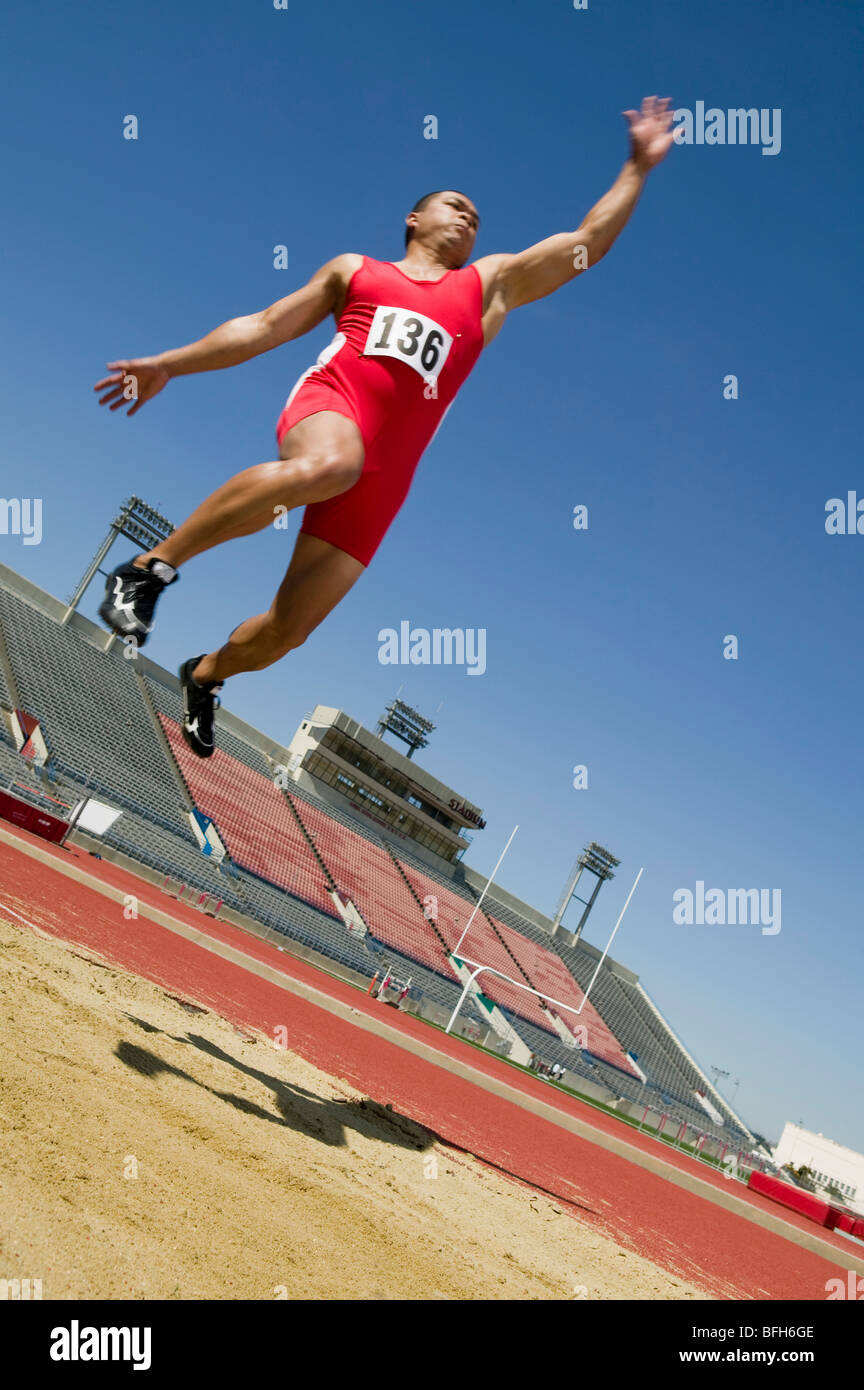 Male athlete long jumping, mid-air Stock Photo - Alamy