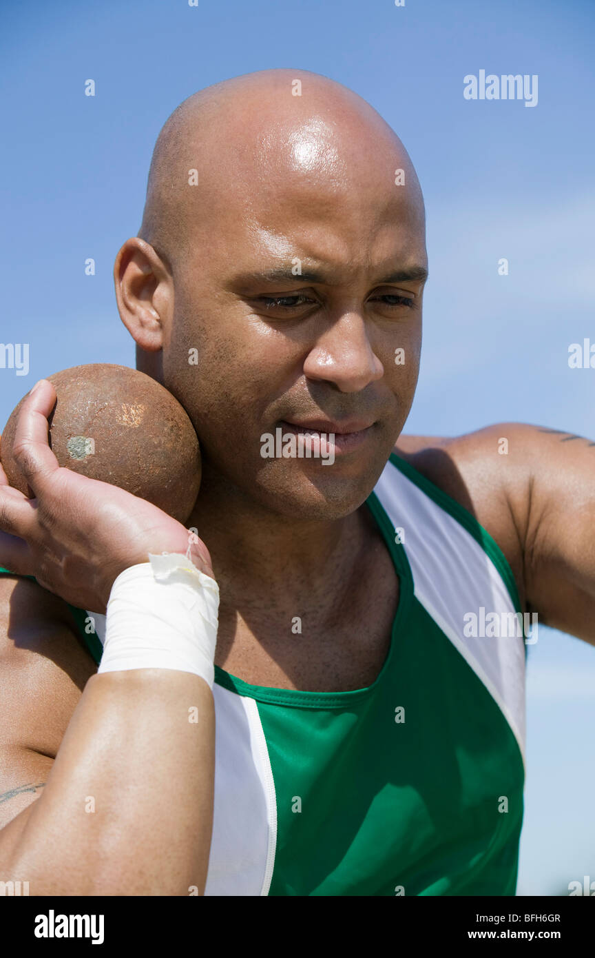 Male shot putter holding shot Stock Photo - Alamy