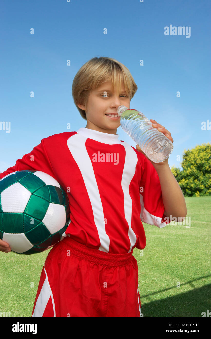 Boy holding soccer ball drinking water hi-res stock photography and ...