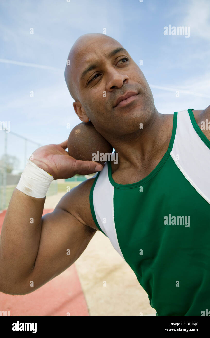 Male shot putter holding shot Stock Photo - Alamy