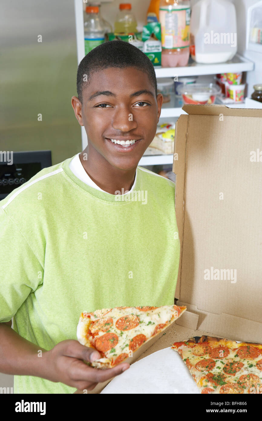 Young man eating pizza at home Stock Photo - Alamy