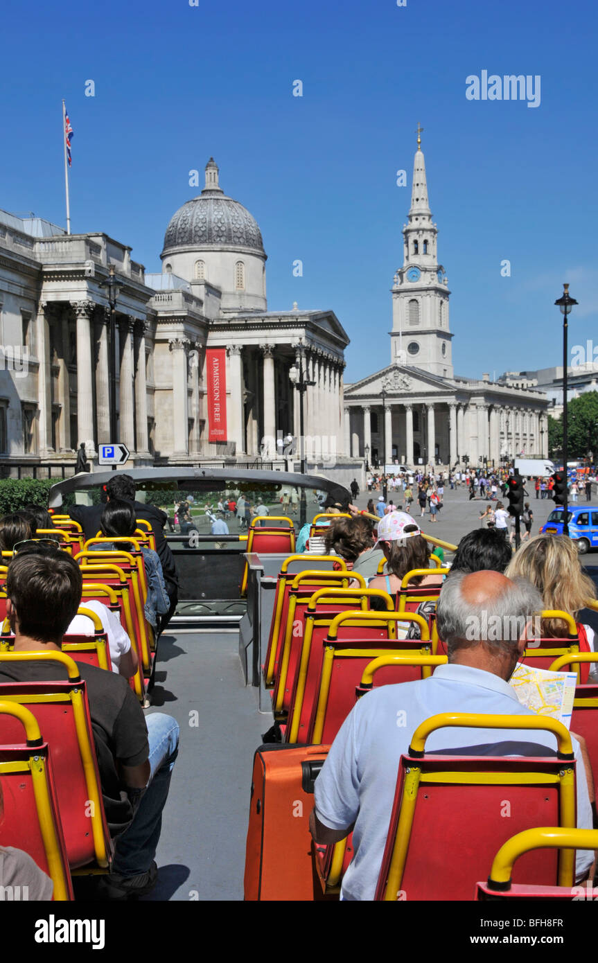 Passengers on open top tour bus approaching Trafalgar Square Stock ...