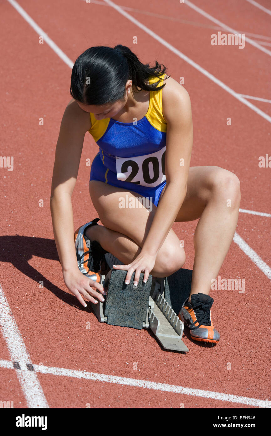 Female athlete stetting up starting block Stock Photo - Alamy