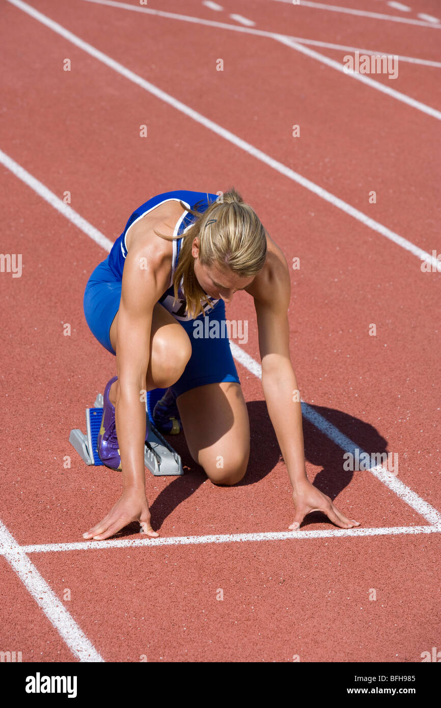 Female athlete in starting block, ready to run Stock Photo - Alamy