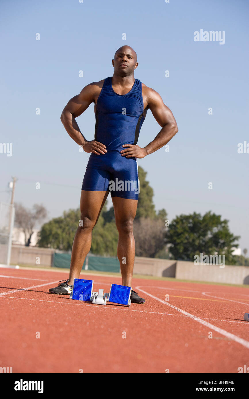 Athlete standing next to starting block, ready to run Stock Photo - Alamy