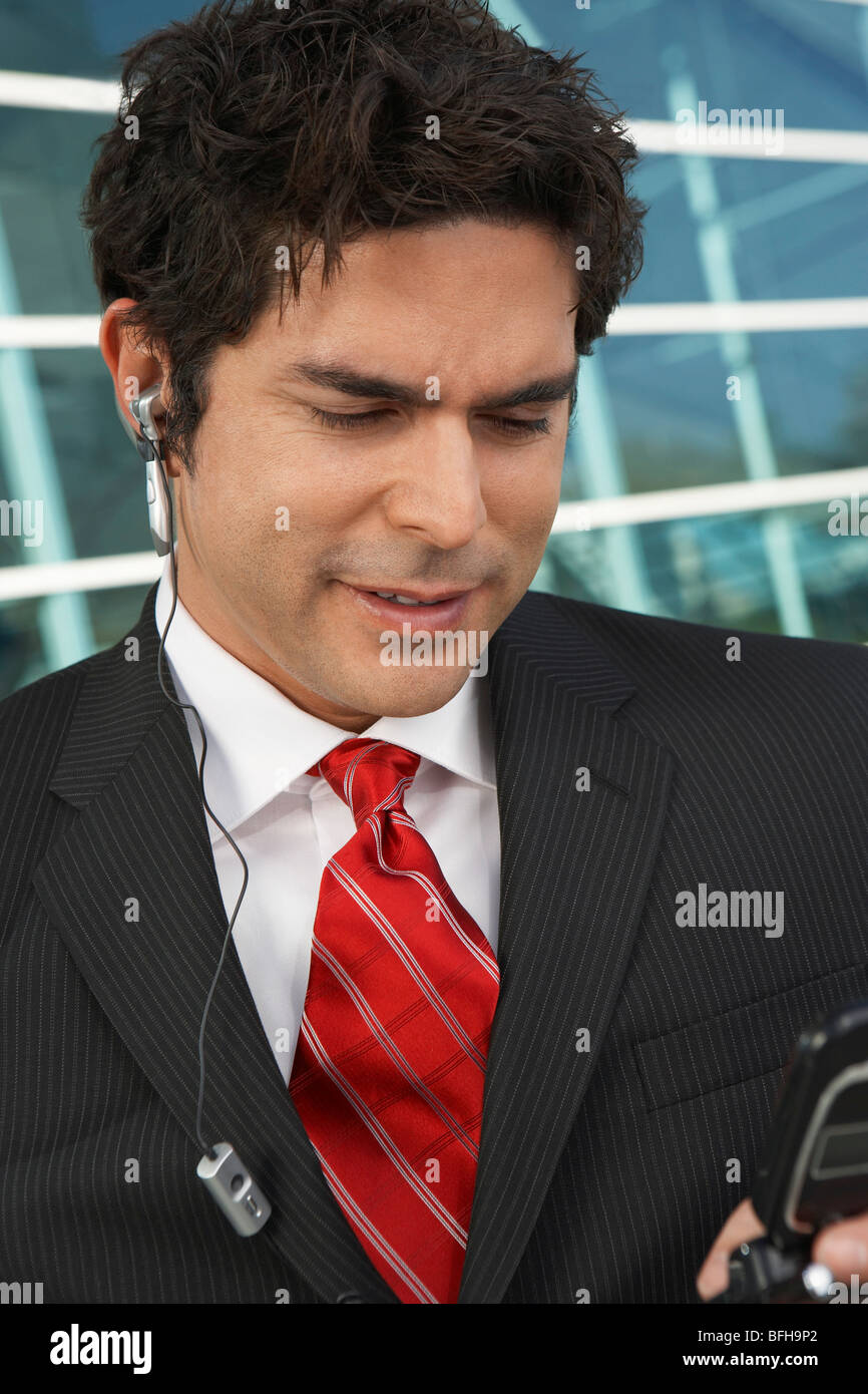 Businessman with earpiece, outdoors Stock Photo - Alamy