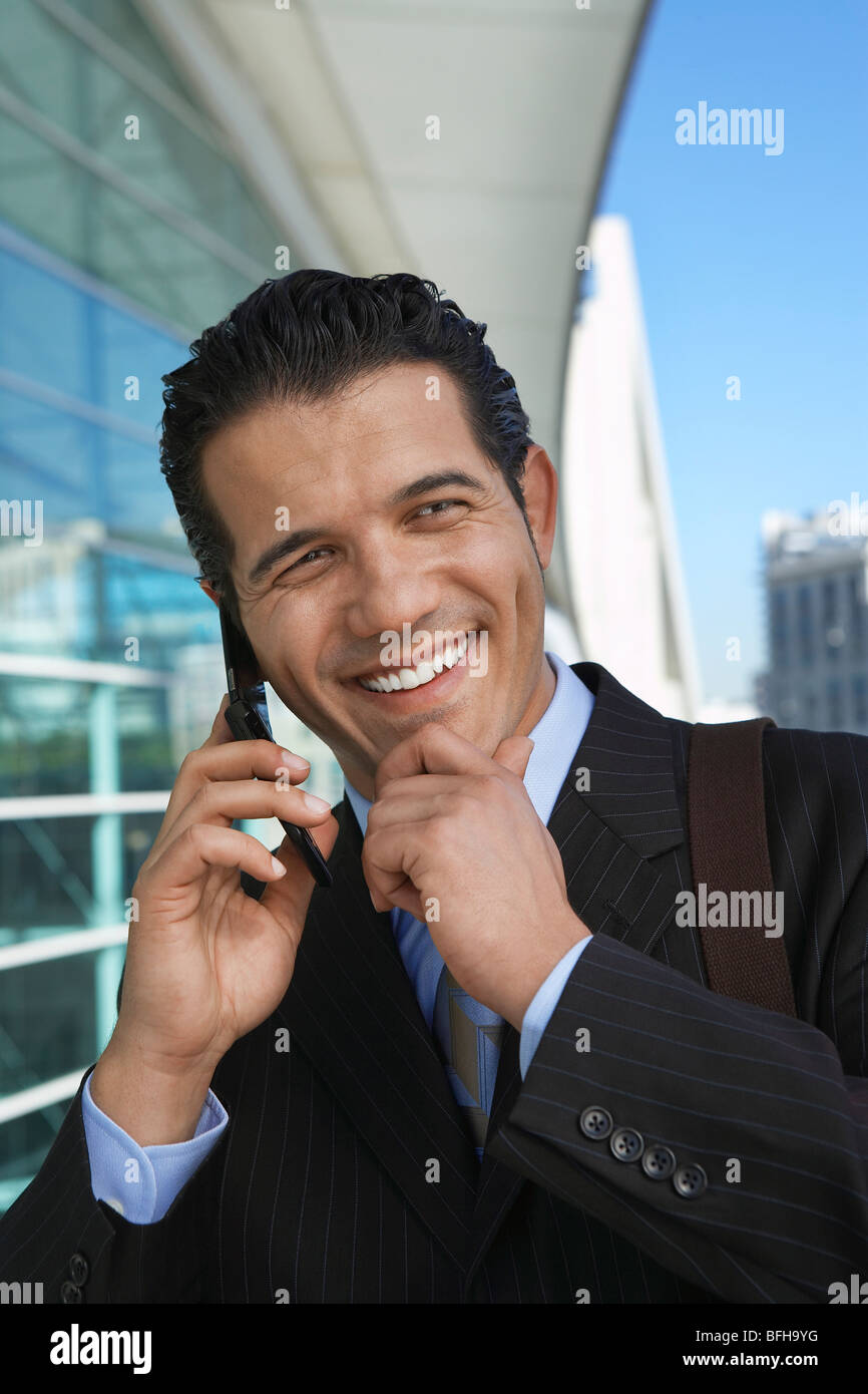Businessman using mobile phone outside office building Stock Photo - Alamy