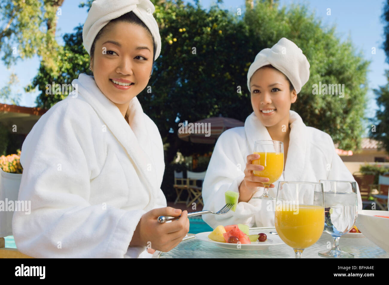 Two young women eating breakfast at outdoor table Stock Photo - Alamy