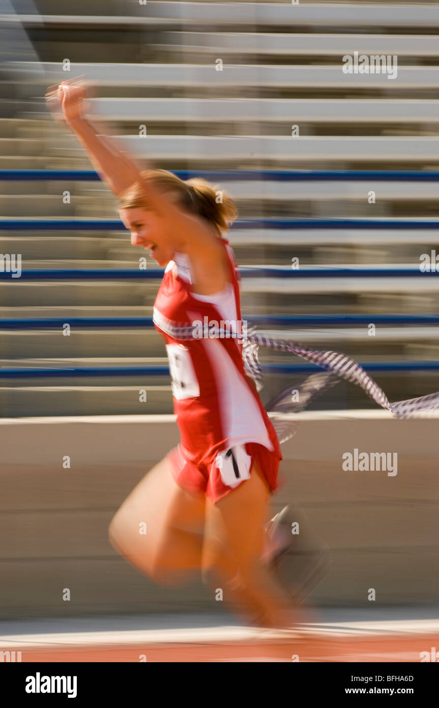 Female track athlete crossing finishing line Stock Photo - Alamy
