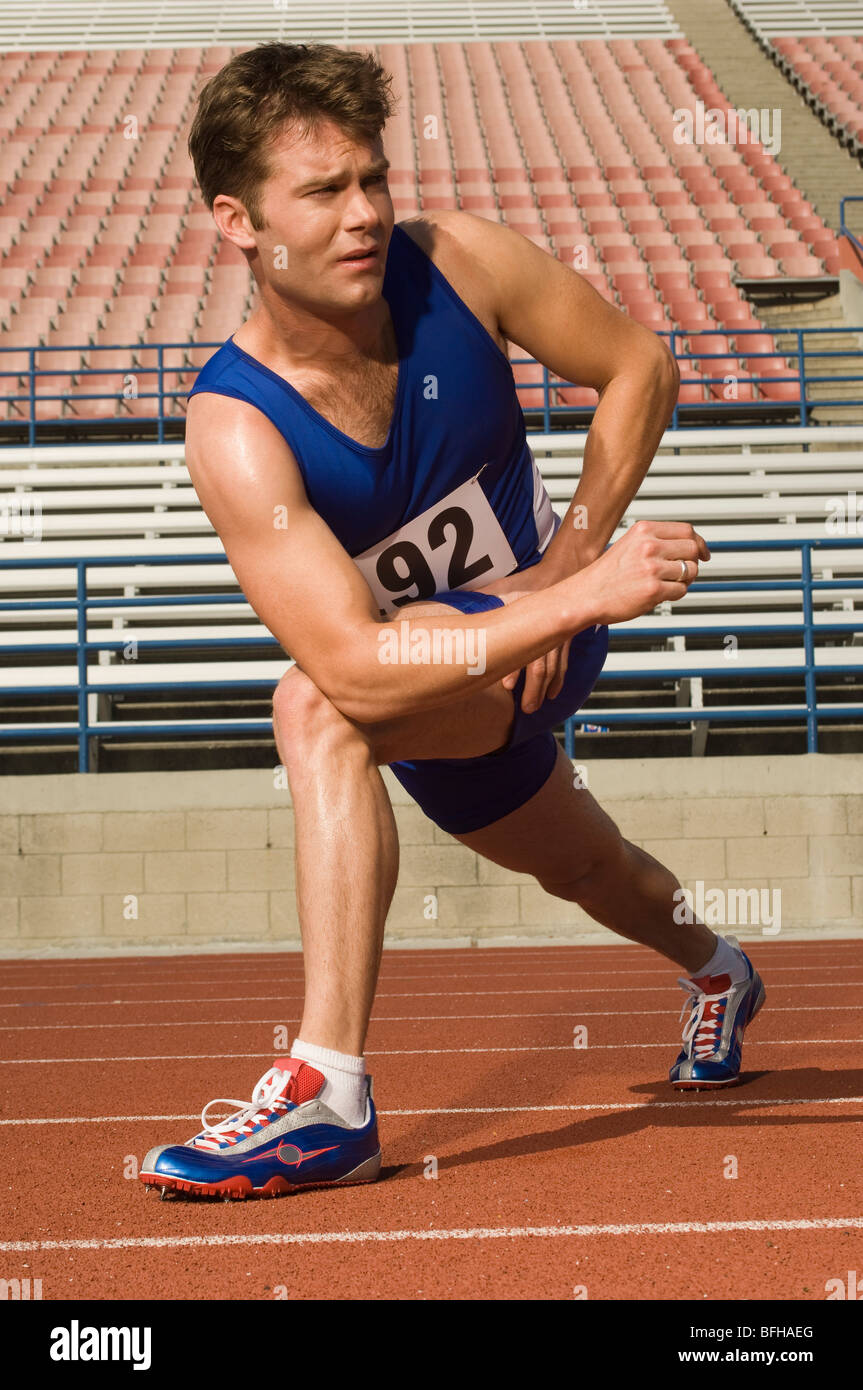 Runner on a track, stretching Stock Photo - Alamy