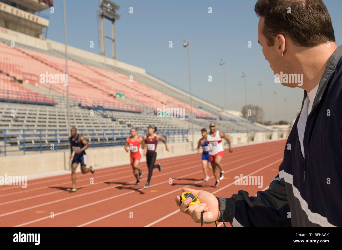 Trainer timing runners on track Stock Photo - Alamy
