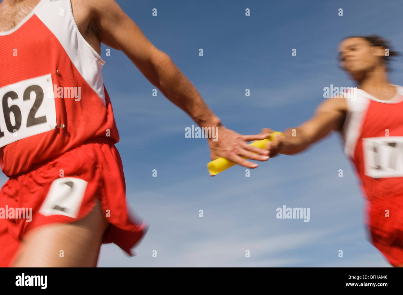 Athletes passing relay baton Stock Photo - Alamy
