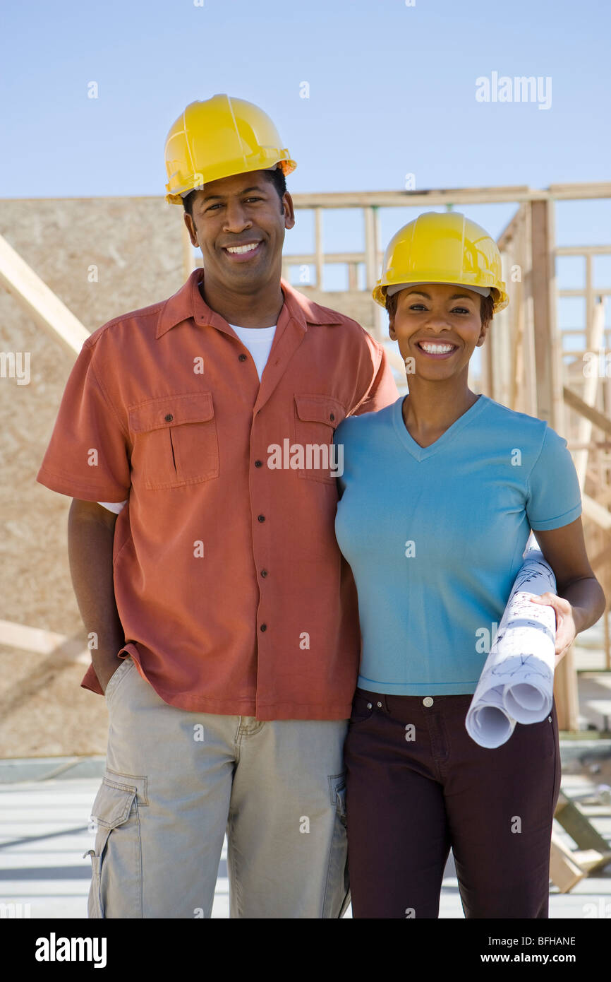 Couple holding building plans on construction site Stock Photo - Alamy