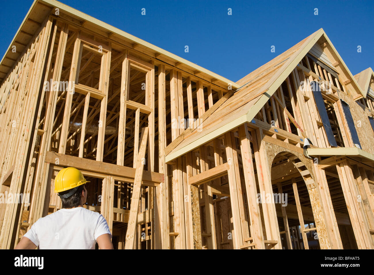 Construction worker observing unfinished house Stock Photo - Alamy