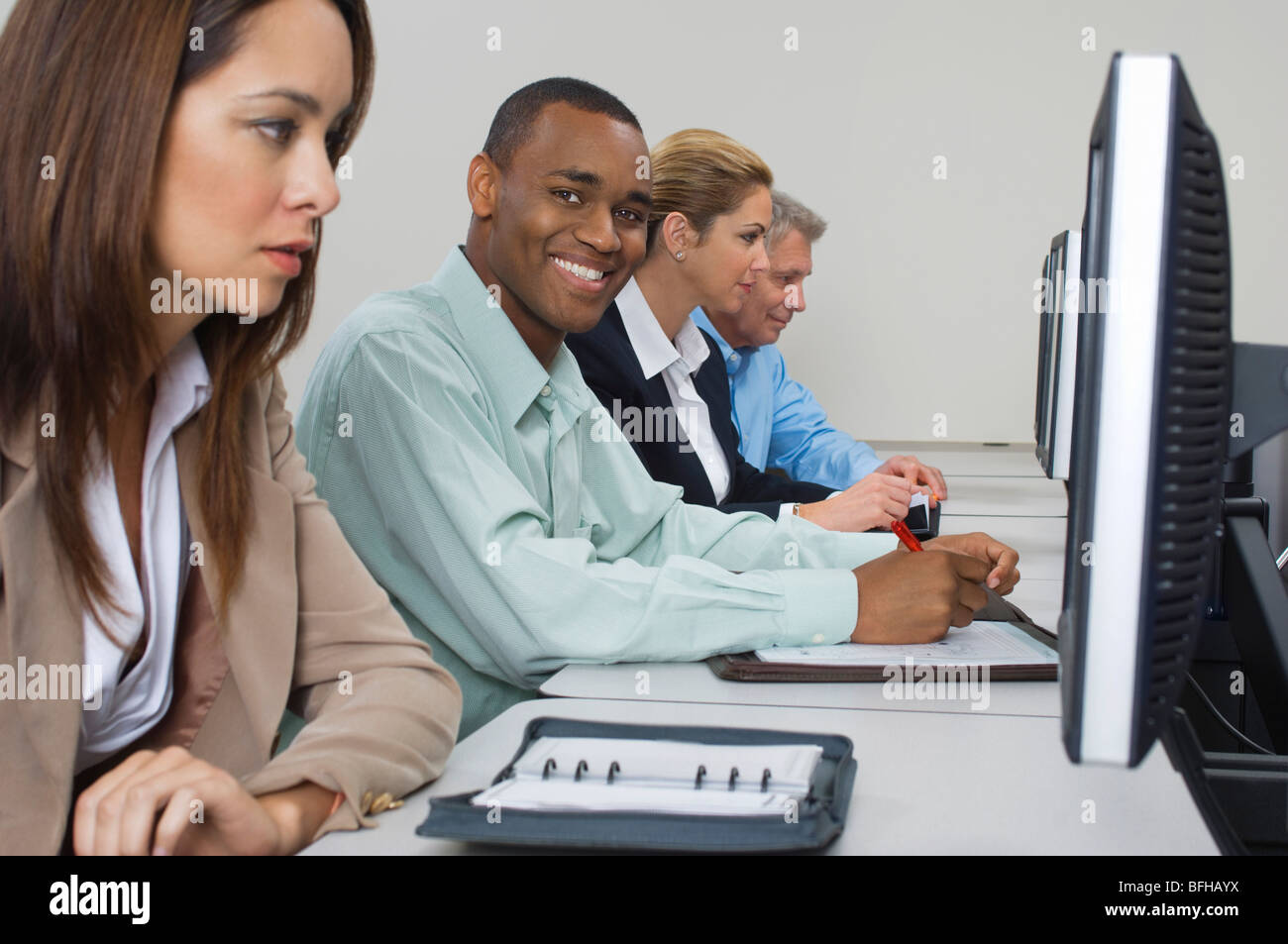 Group of business people using computers in classroom, side view Stock ...
