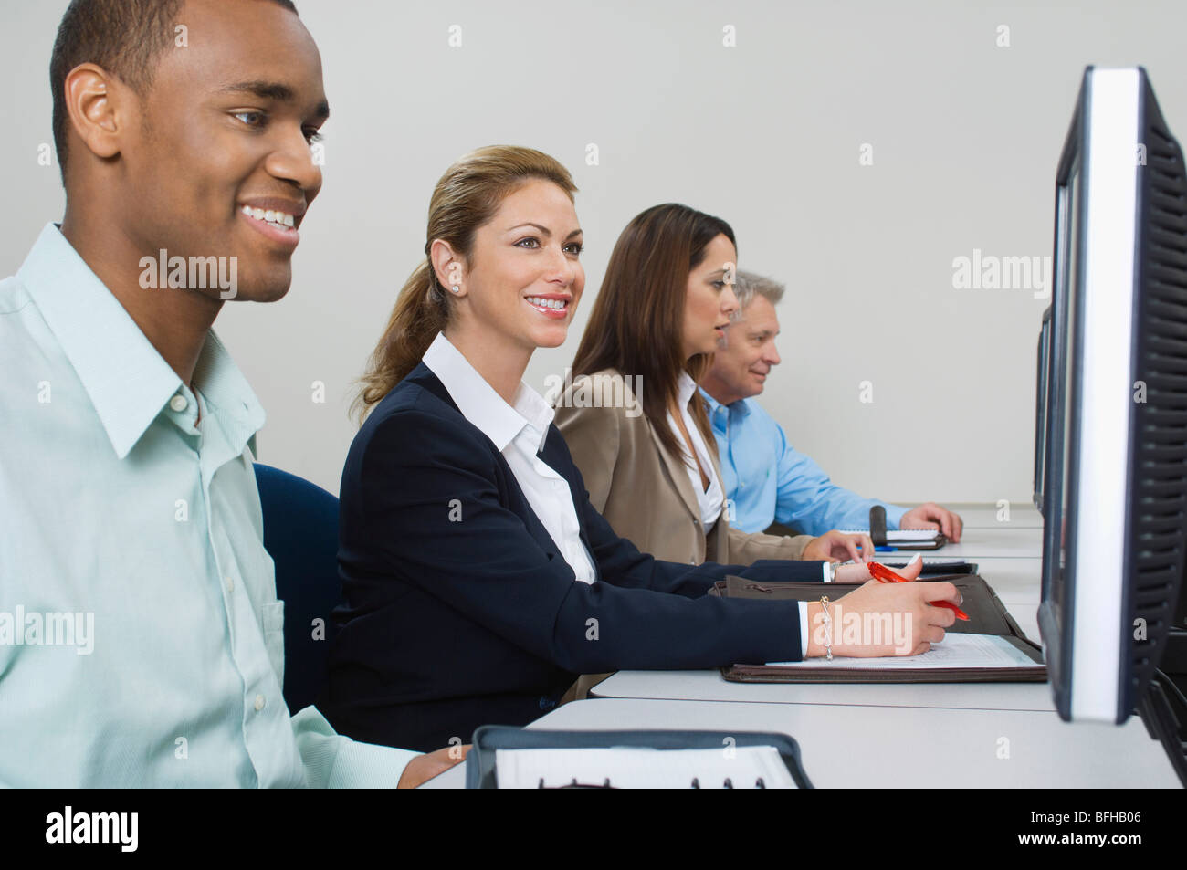 Group of business people using computers in classroom, side view Stock ...