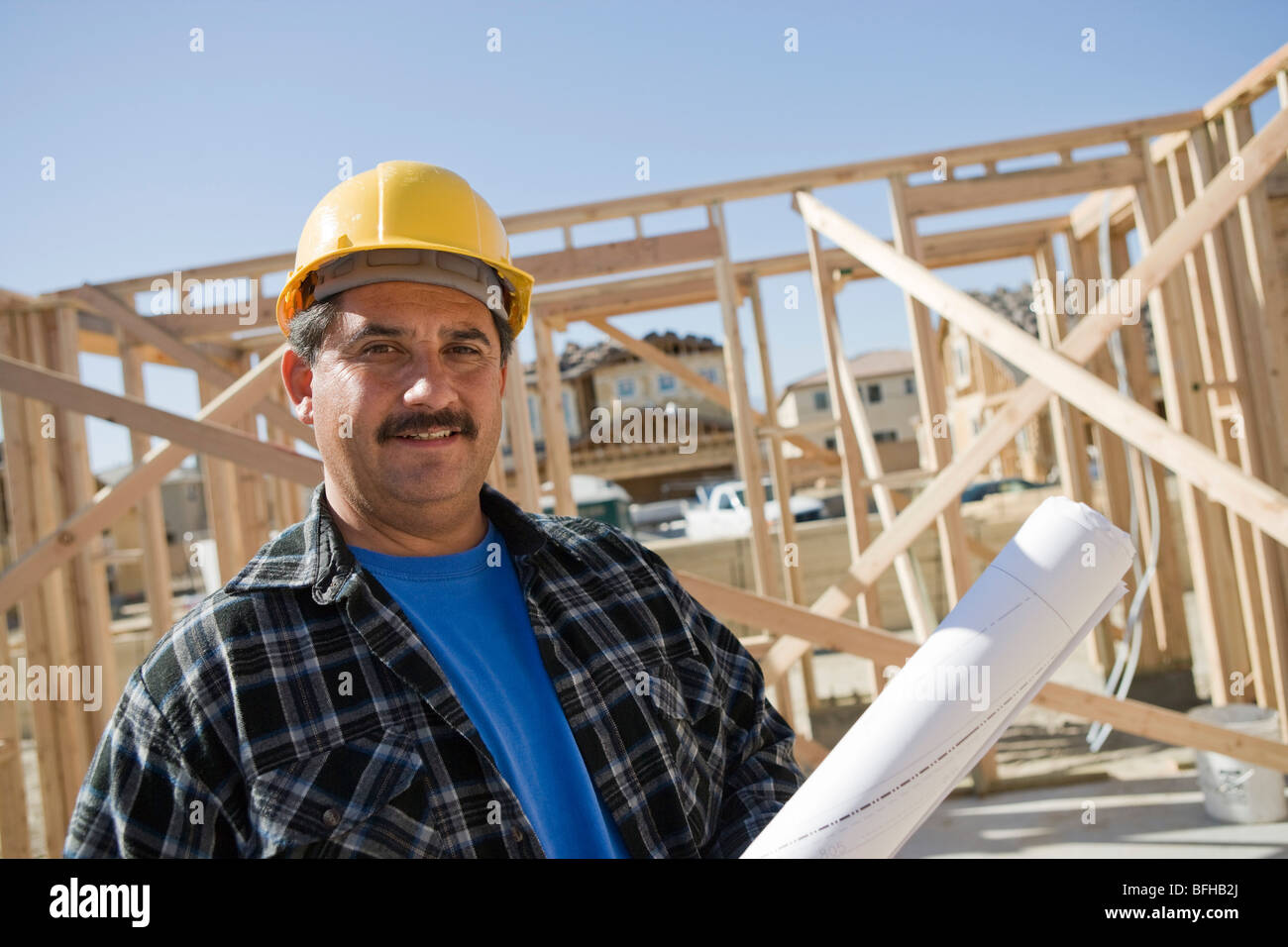 Construction worker holding building plans Stock Photo - Alamy