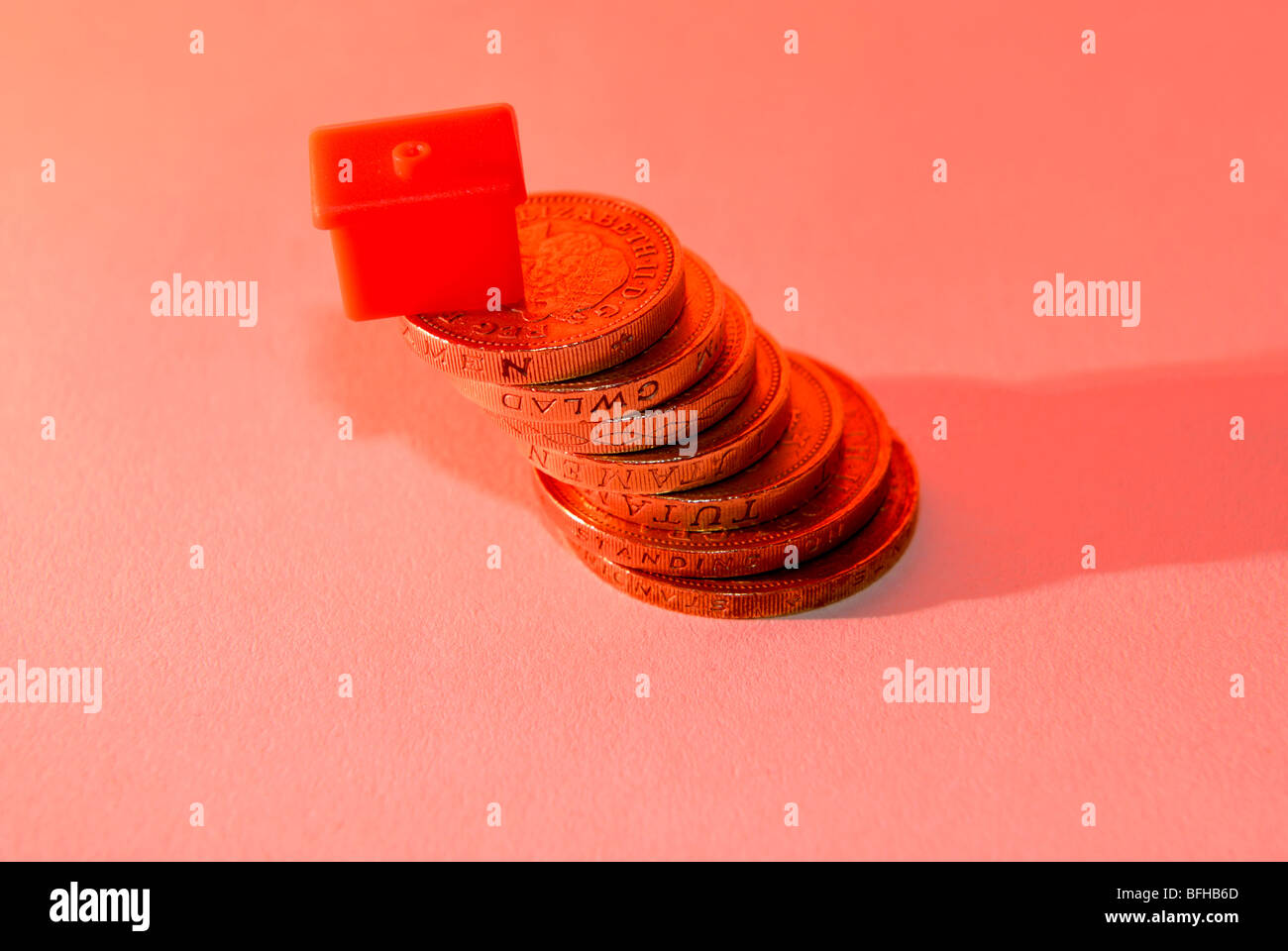 generic finance and housing image with monopoly house and pile of pound ...