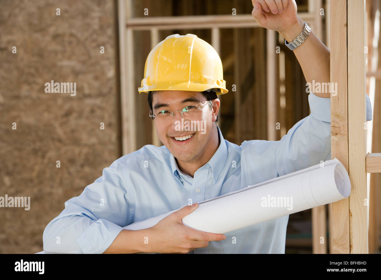 Man holding rolled up blueprint in construction site Stock Photo - Alamy