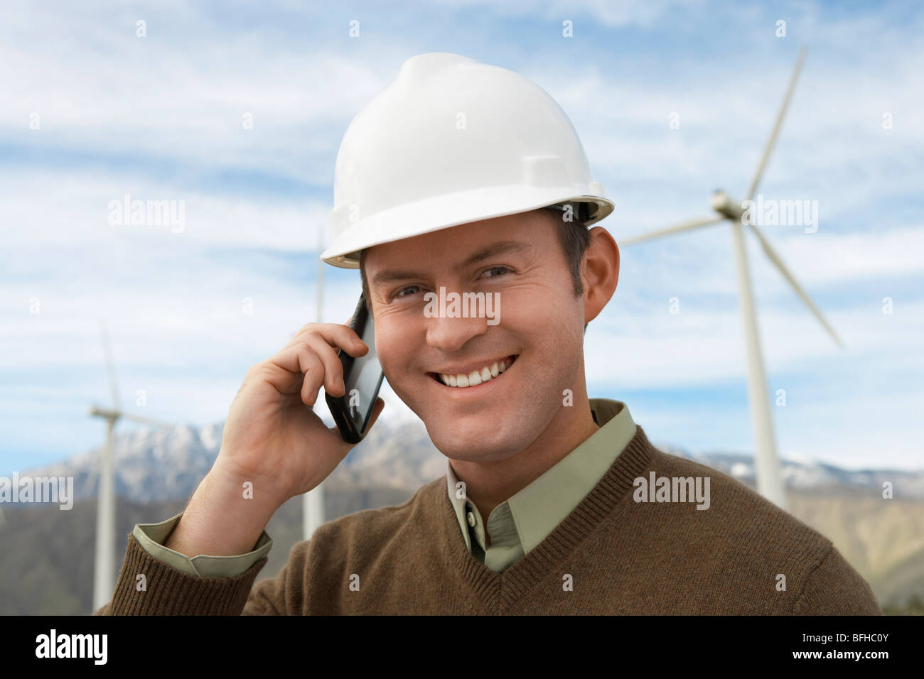 Engineer using mobile phone at wind farm, portrait Stock Photo - Alamy