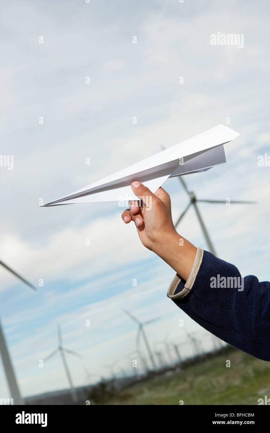 Boys hand throwing paper plane at wind farm, close-up Stock Photo - Alamy