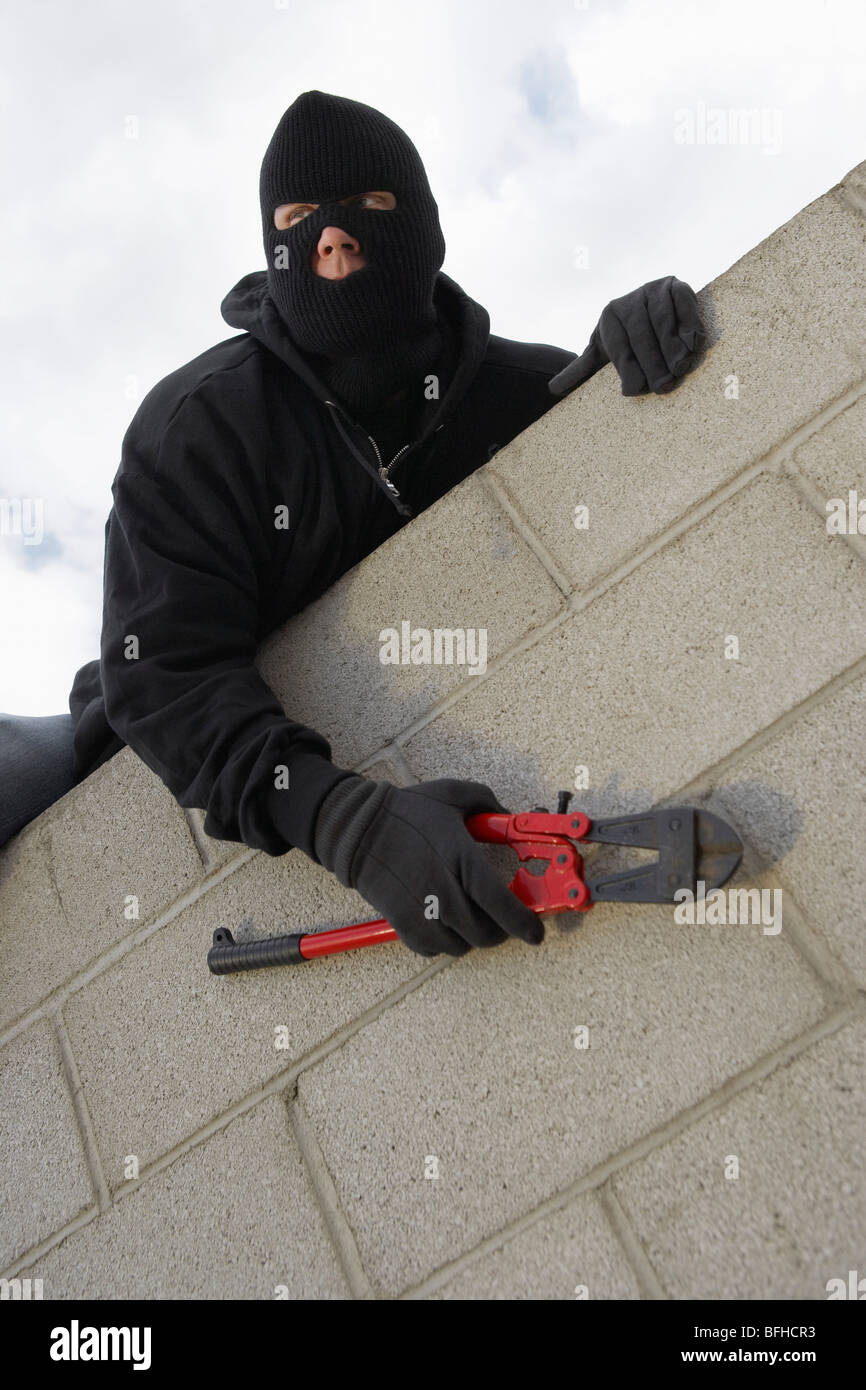 Masked thief climbing wall Stock Photo - Alamy
