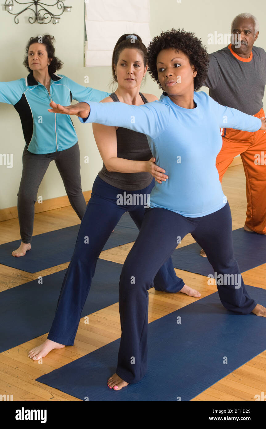 Yoga Instructor Assisting Woman in Yoga Class Stock Photo - Alamy