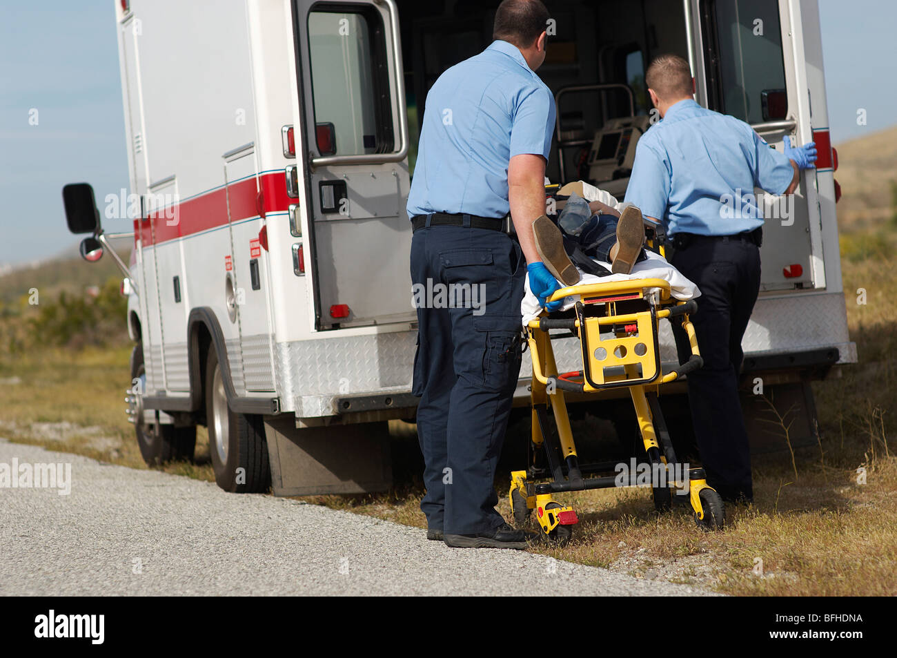 Paramedics transporting victim on stretcher Stock Photo - Alamy