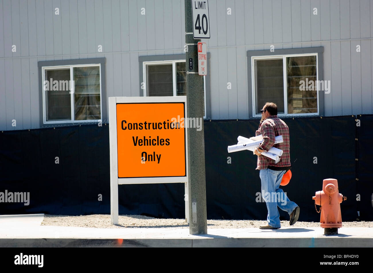 Engineer with drawings enters a construction area Stock Photo - Alamy