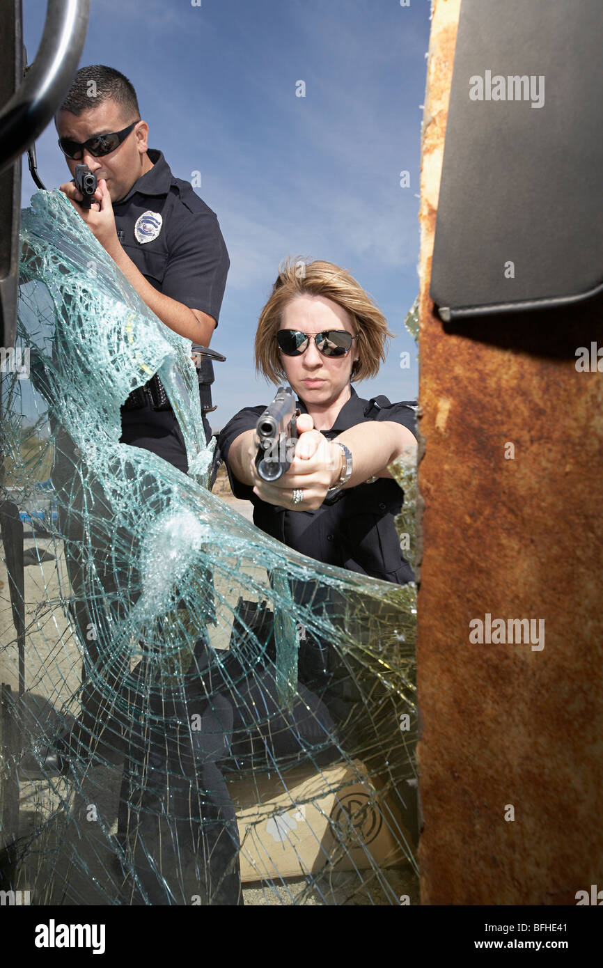 Police officers aiming guns through broken car windshield Stock Photo ...