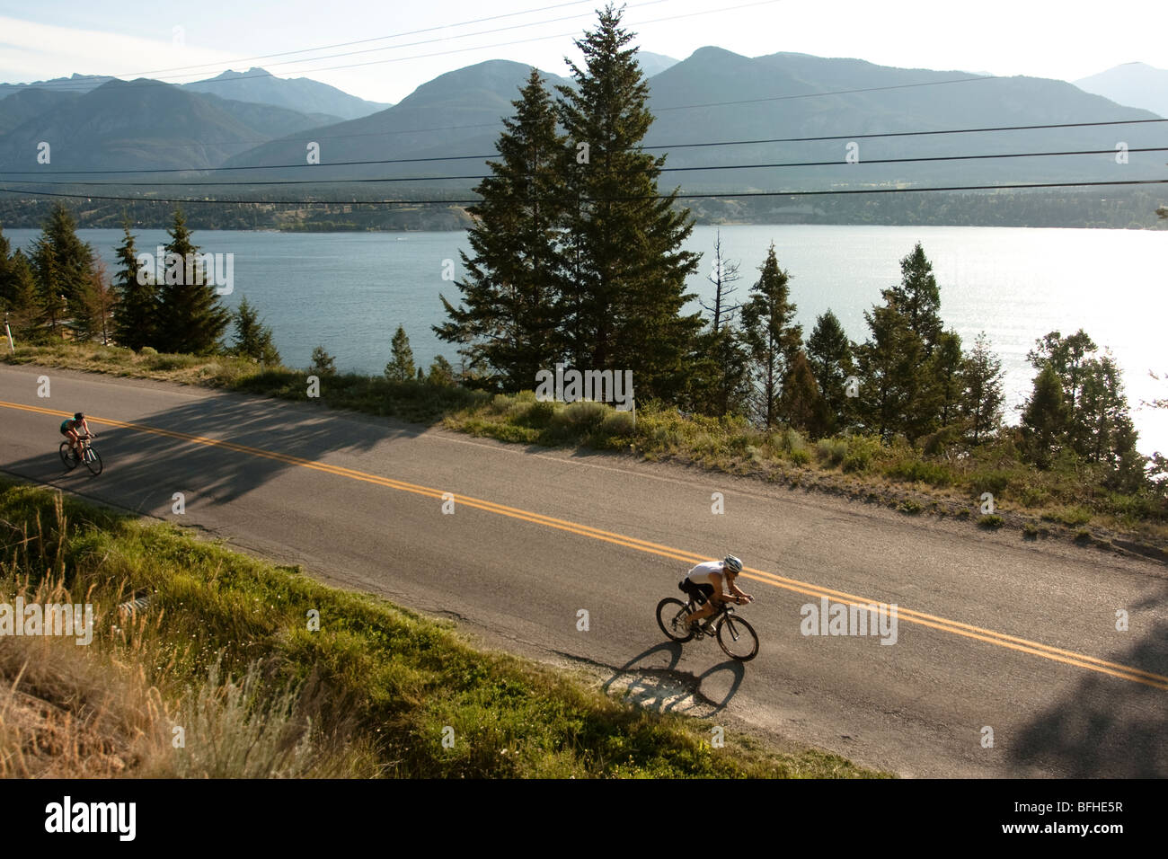 A Road cyclist rides along the shore of Windermere lake, Invermere B.C ...