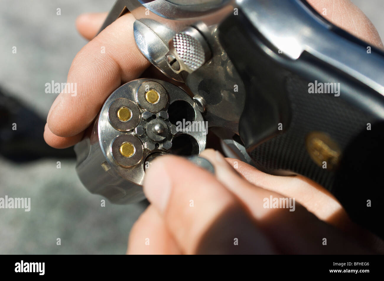 Man loading bullets into gun, close-up of hands Stock Photo - Alamy
