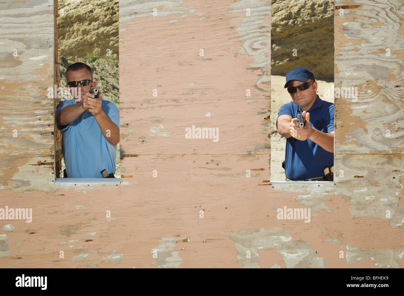Two men aiming hand guns at firing range Stock Photo - Alamy