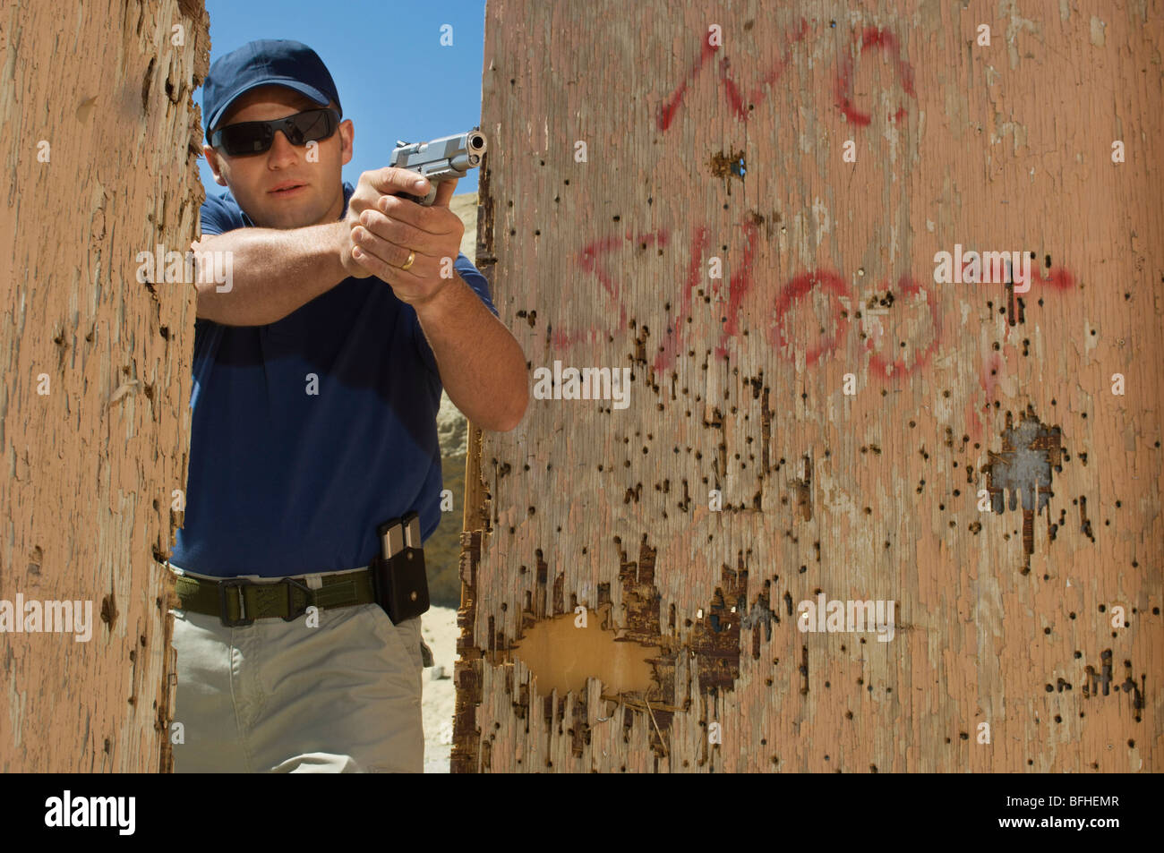 Man aiming hand gun at firing range Stock Photo - Alamy