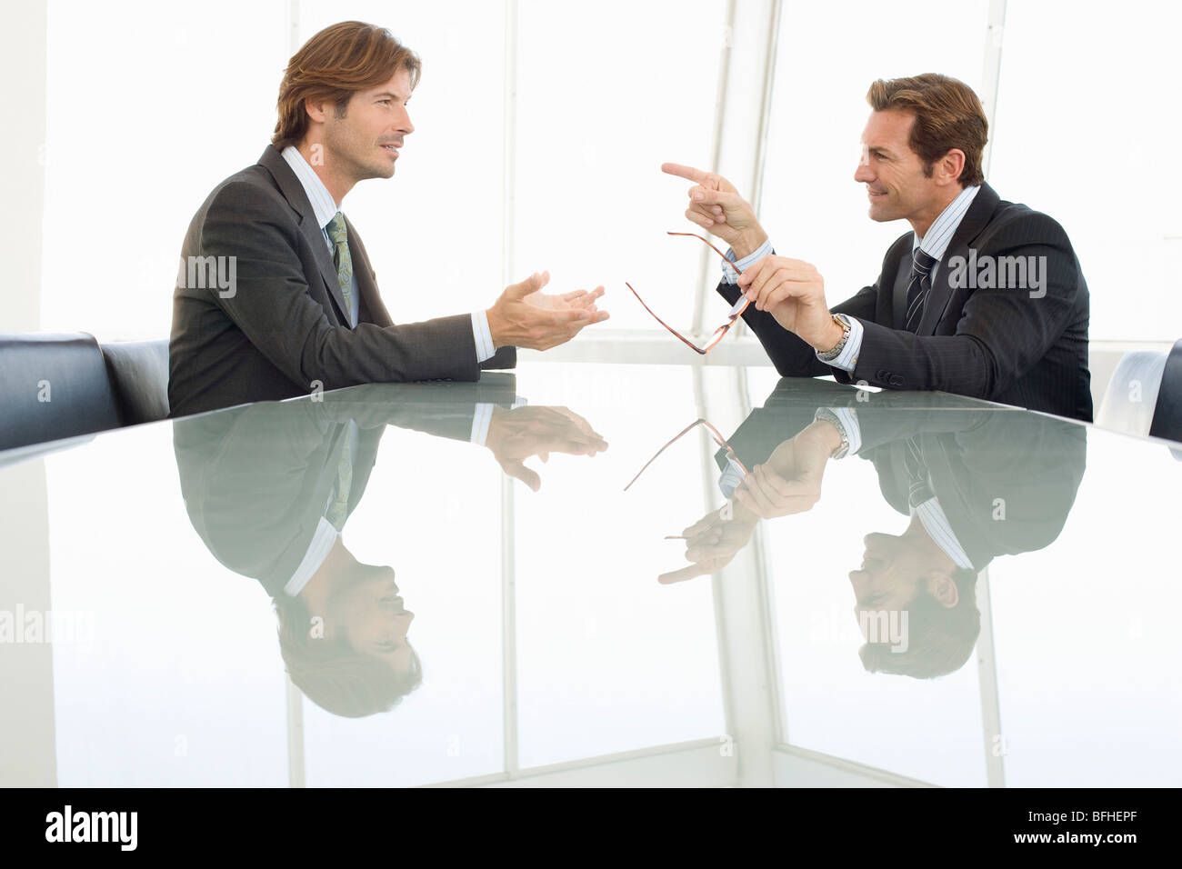 Business men talking at conference table Stock Photo - Alamy