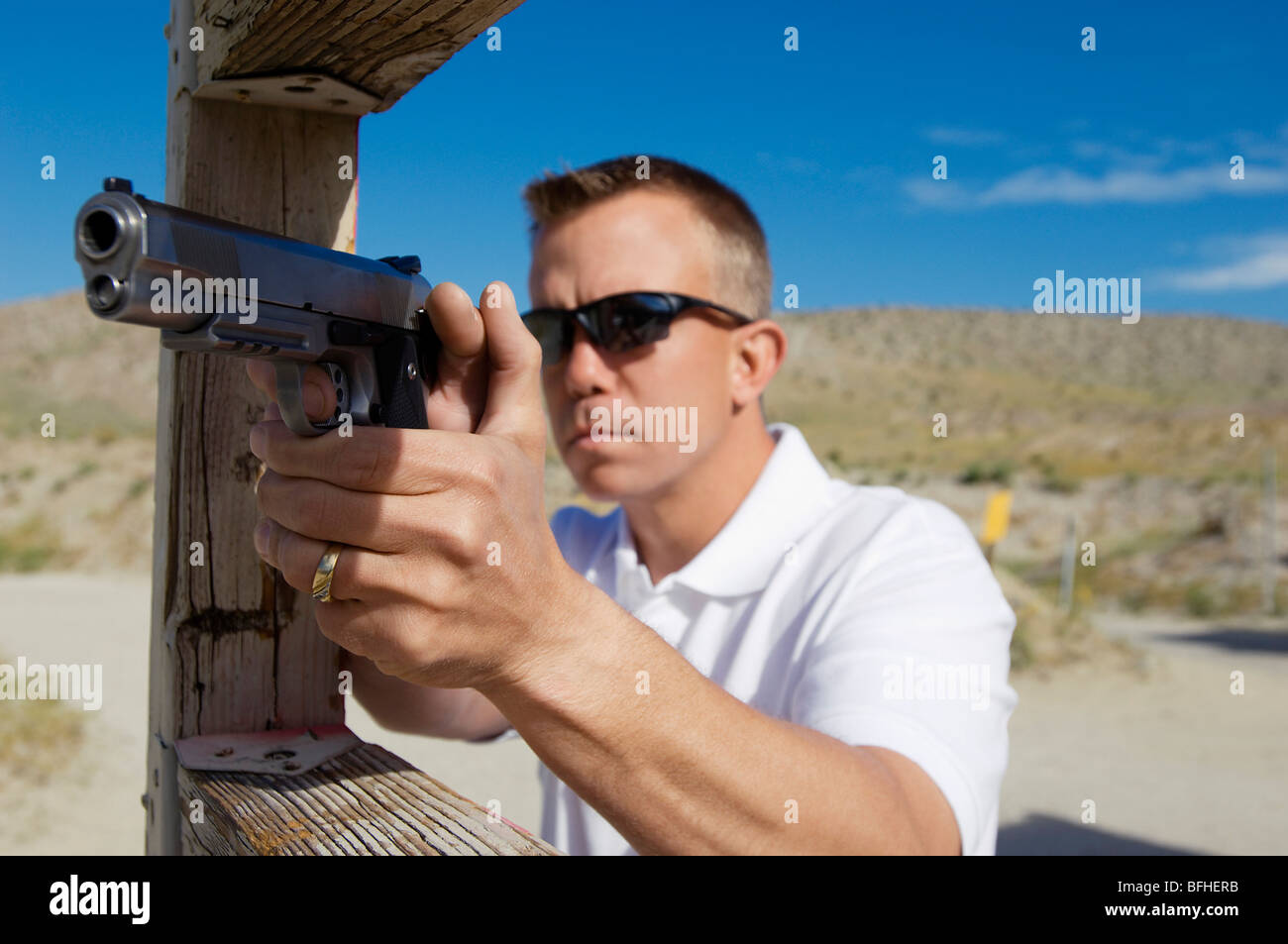 Man aiming hand gun at firing range Stock Photo - Alamy