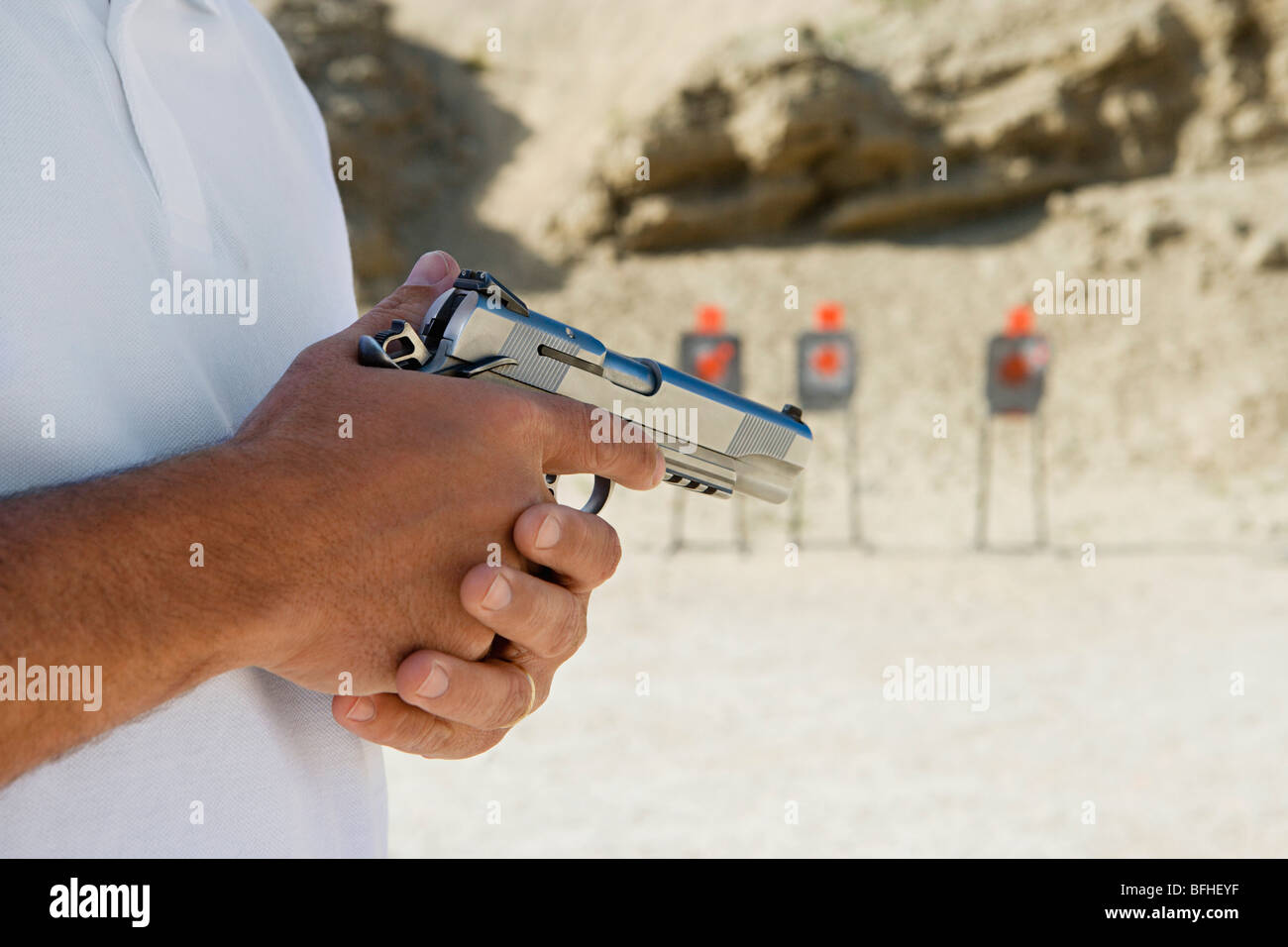 Man holding hand gun at firing range, portrait Stock Photo - Alamy