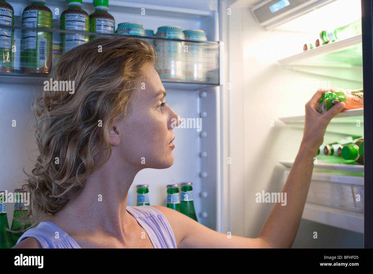 Young woman looking for food in fridge Stock Photo - Alamy