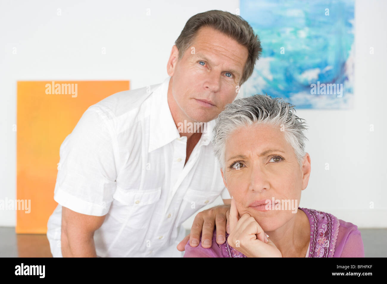 Couple contemplating paintings in gallery Stock Photo - Alamy