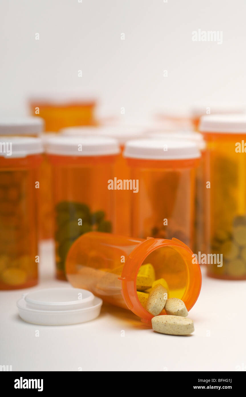 Bottles of pills, one spilling, close-up Stock Photo - Alamy