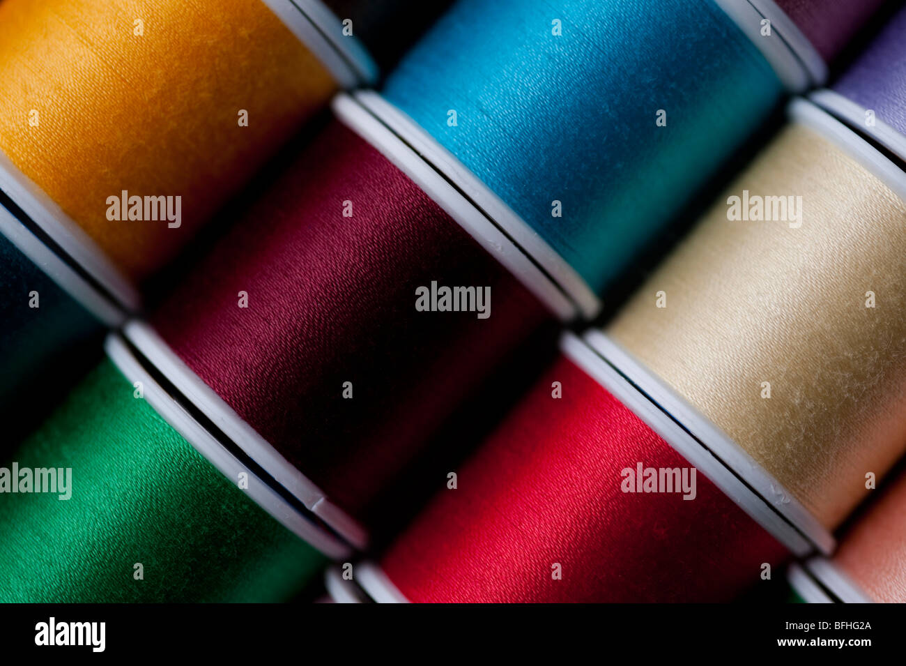 Bright colored spools of thread in rows Stock Photo - Alamy