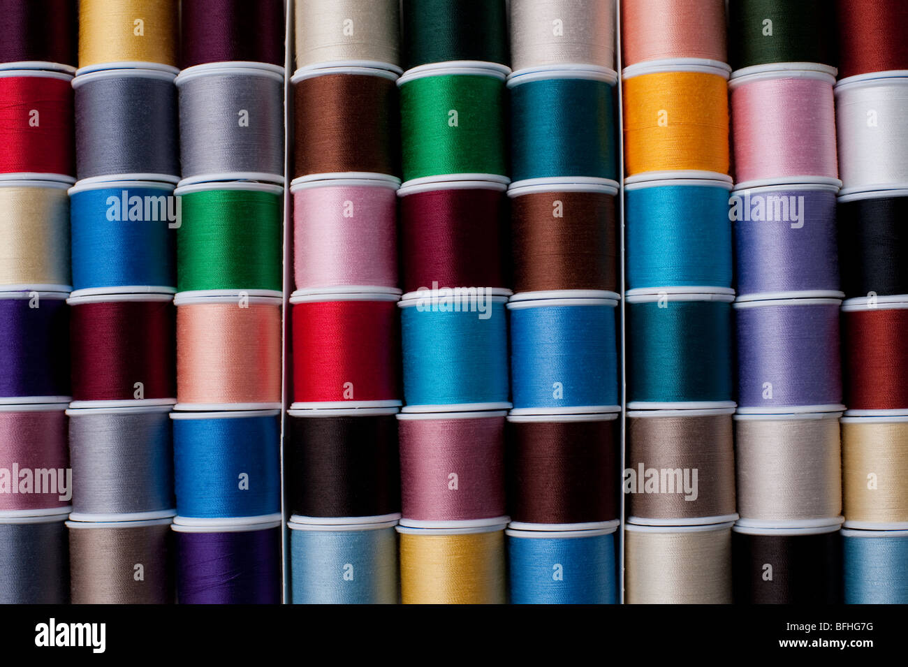 Bright colored spools of thread in rows Stock Photo - Alamy