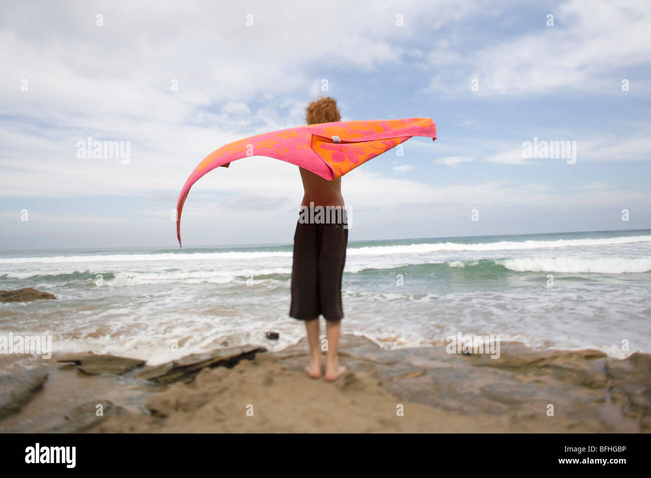 Back view of boy standing on beach and watching sea Stock Photo - Alamy